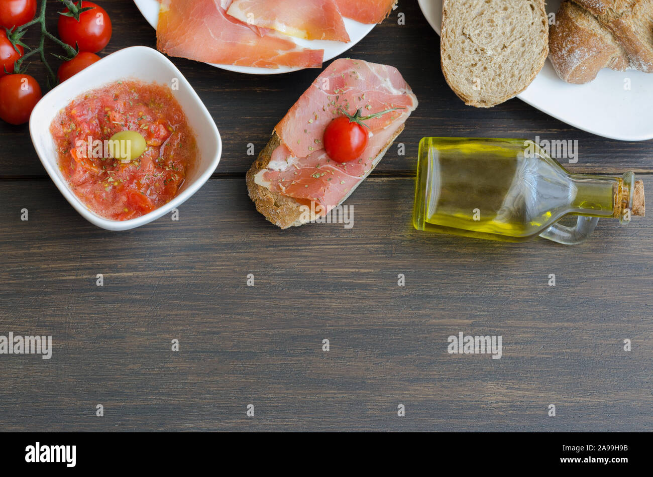 Top view of Spanish tapa with Jamon Iberico( Iberian ham), tumaca bowl ...