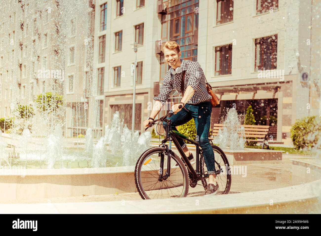 Positive delighted male person riding his bicycle Stock Photo - Alamy
