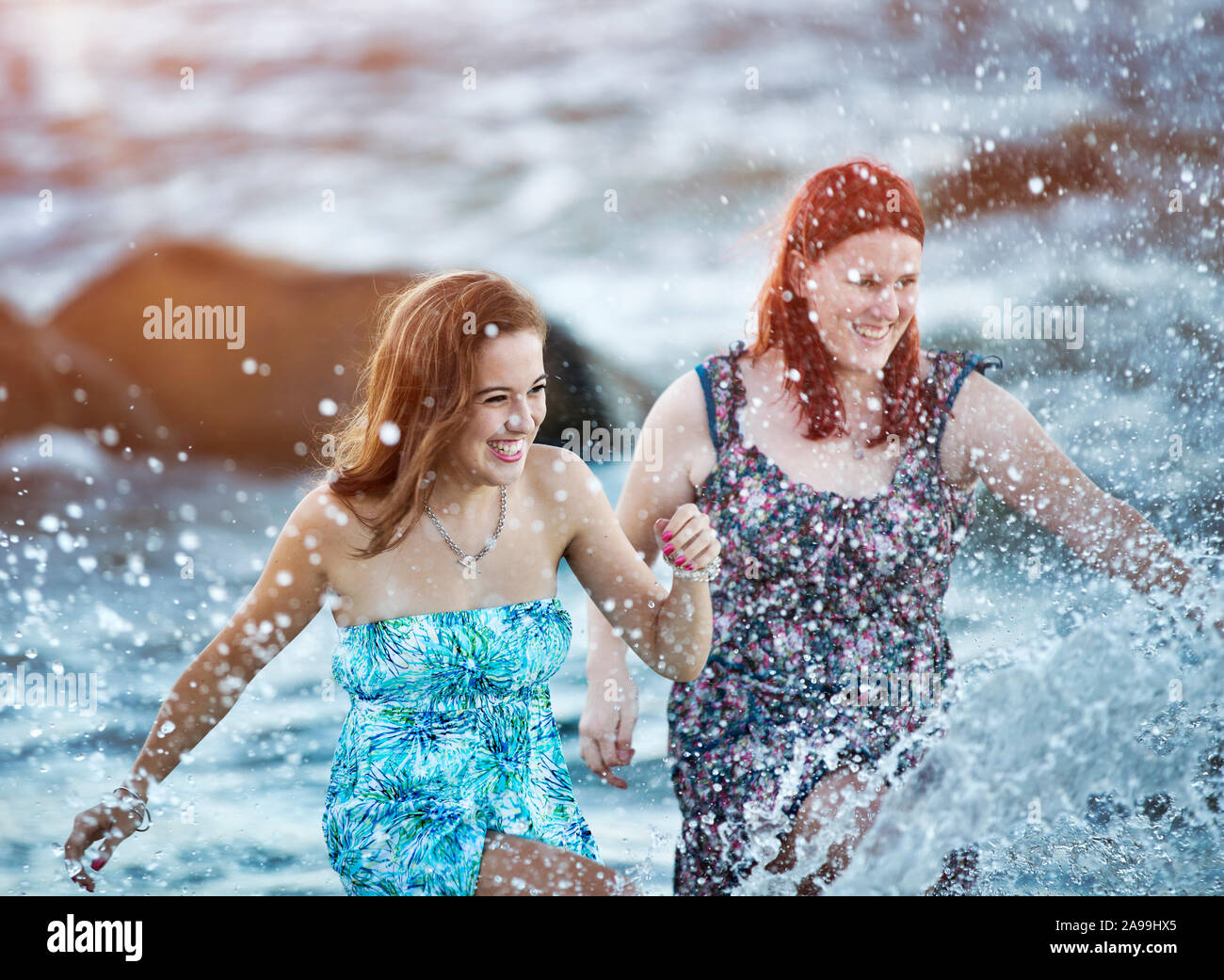 Two friends running into the ocean hi-res stock photography and images ...