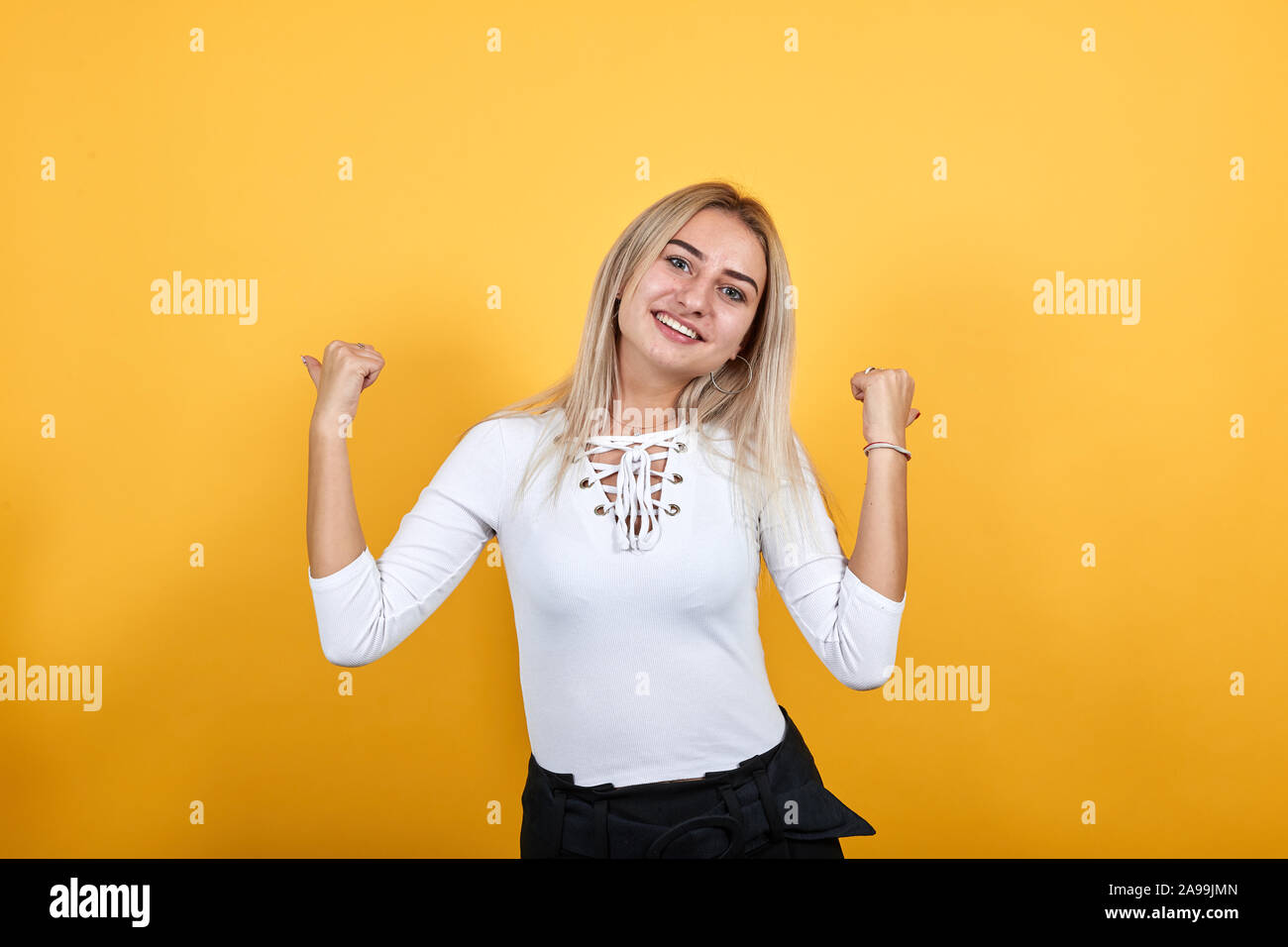 Pretty girl celebrating a victory in winner position, keeping hands ...