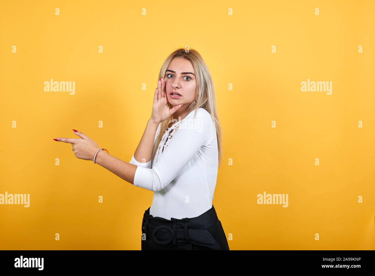 Attractive young woman shouting and announcing something, keeping hand ...