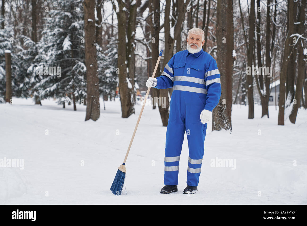 Portrait of elderly cleaner on background of winter park. Janitor ... Portrait of elderly cleaner on background of winter park. Janitor ...