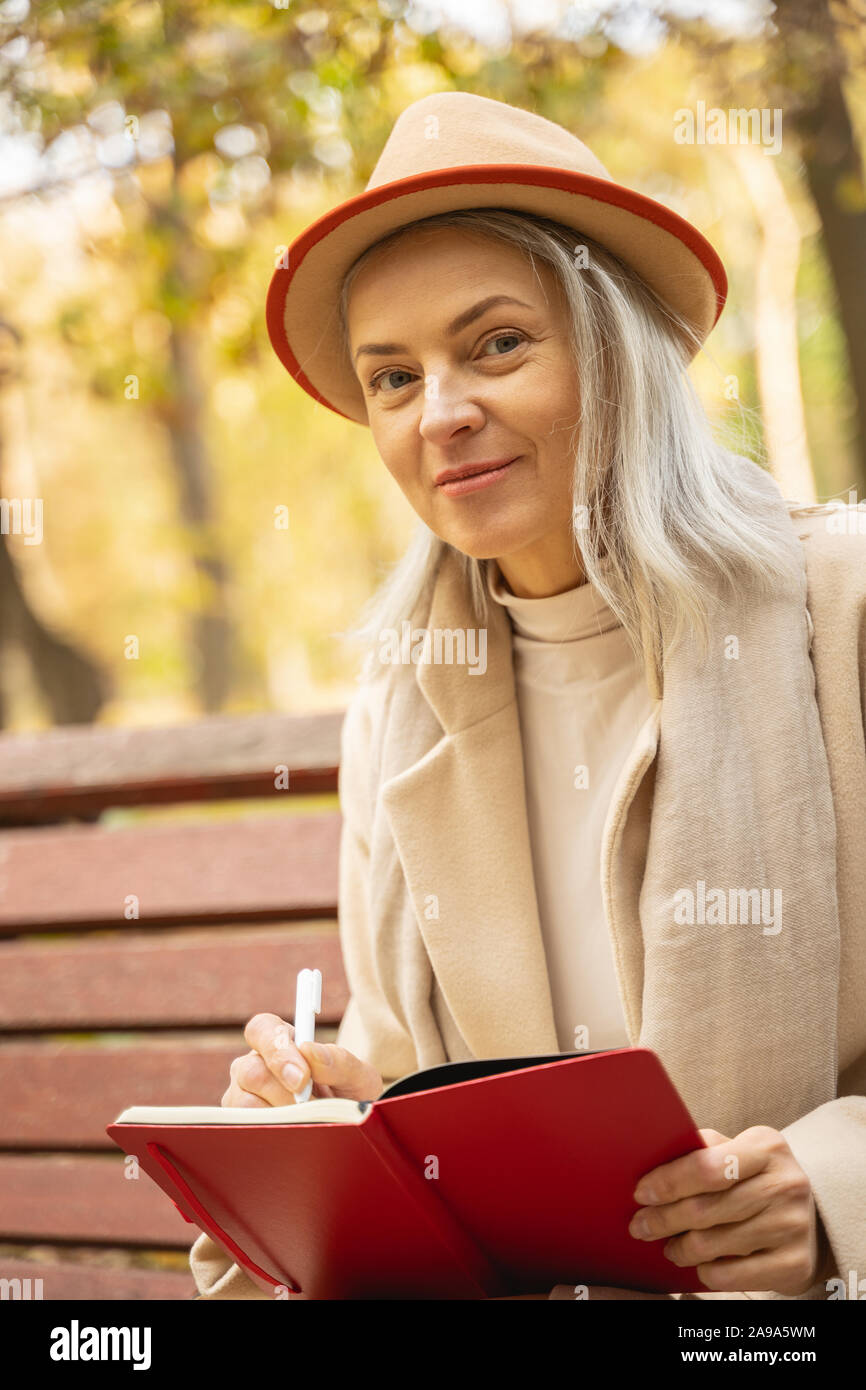 Lady with a pen sitting on the bench Stock Photo - Alamy