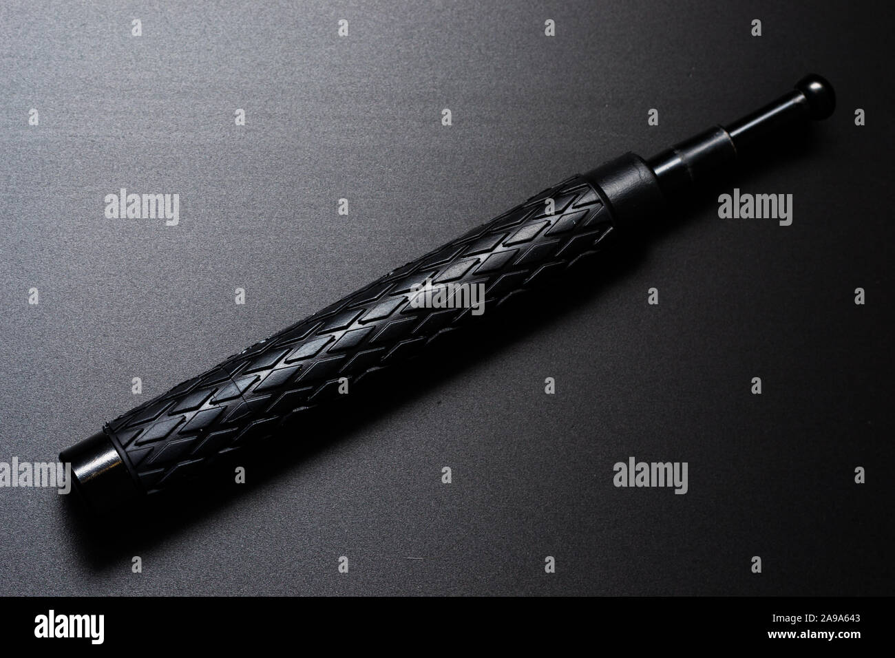 Black telescopic expandable baton / truncheon isolated Stock Photo - Alamy