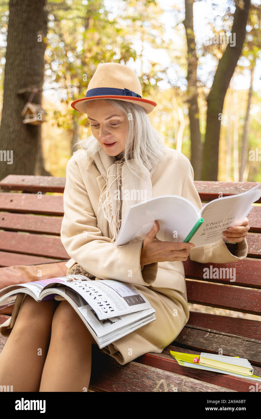 Concentrated Caucasian stylish lady studying English outside Stock ...
