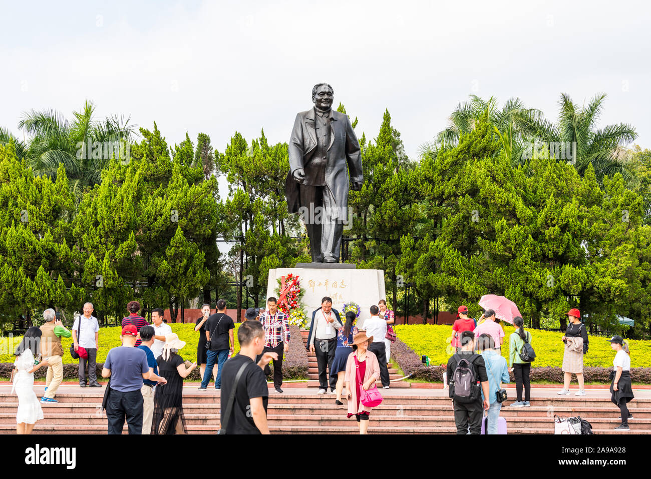 Lots of tourists taking photos in front of statue of Mr Deng Xiaoping in Lianhuashan Park of ...