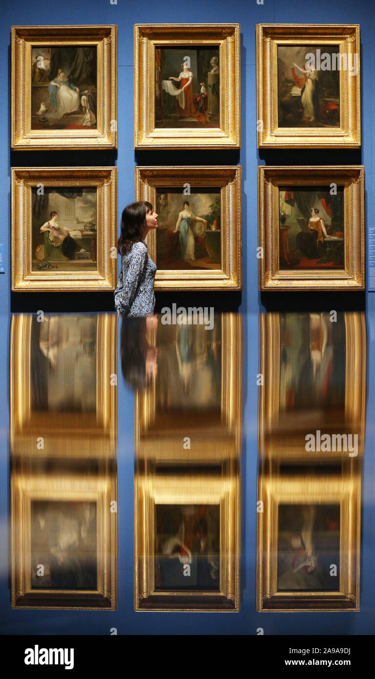 A Royal Collection staff member looks at a collection of portraits of ...