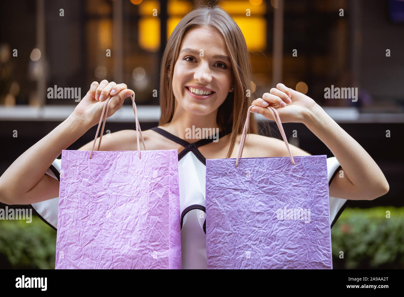 Cheerful lady showing her bought items to a friend Stock Photo - Alamy