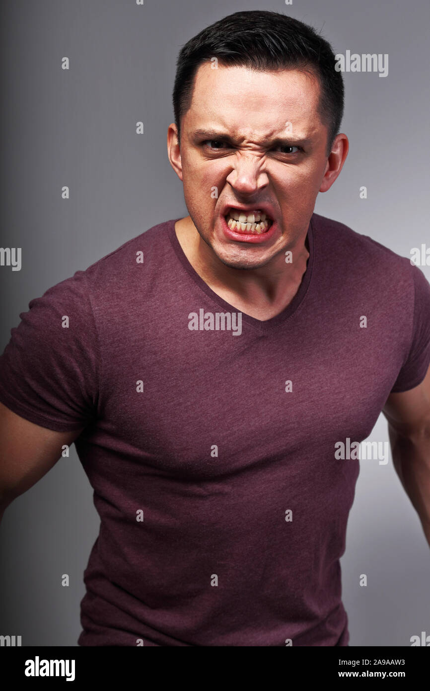 Angry man looking with aggressive eyes and clenched teeth. Closeup ...