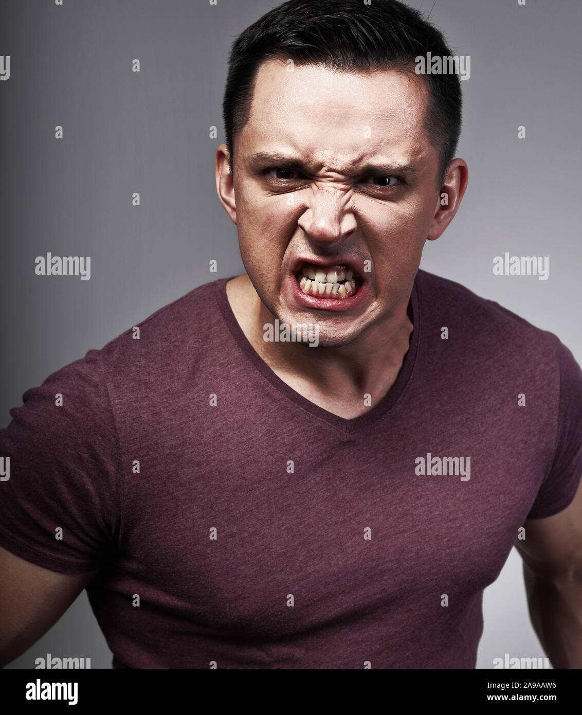 Angry man looking with aggressive eyes and clenched teeth. Closeup ...