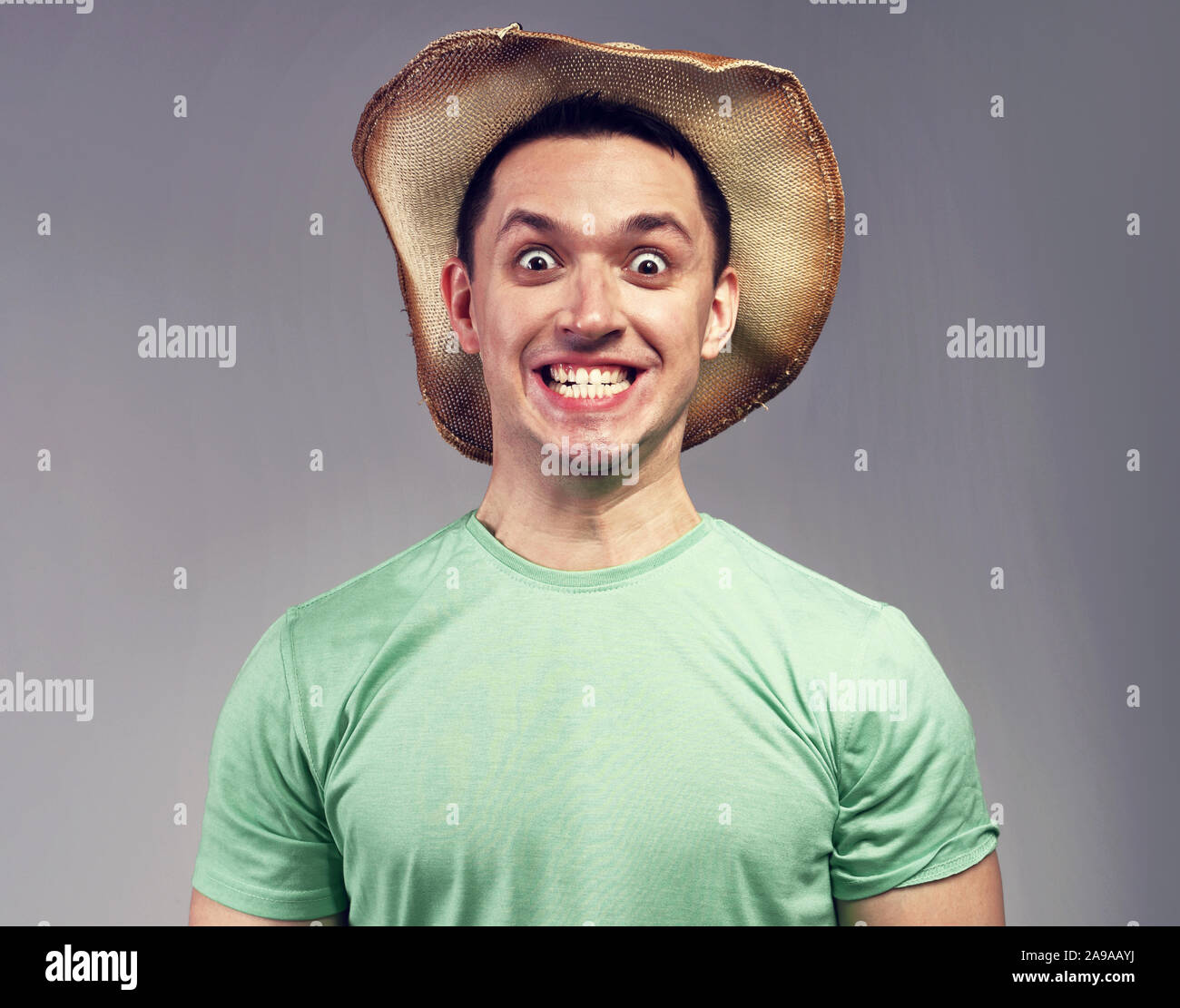 Fun crazy man showing facial grimace with toothy smile on summer hat on ...