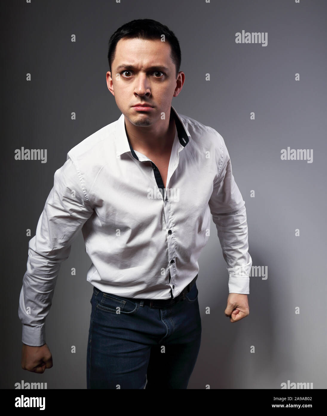 Angry young business man looking with aggressive eyes and holding hands ...