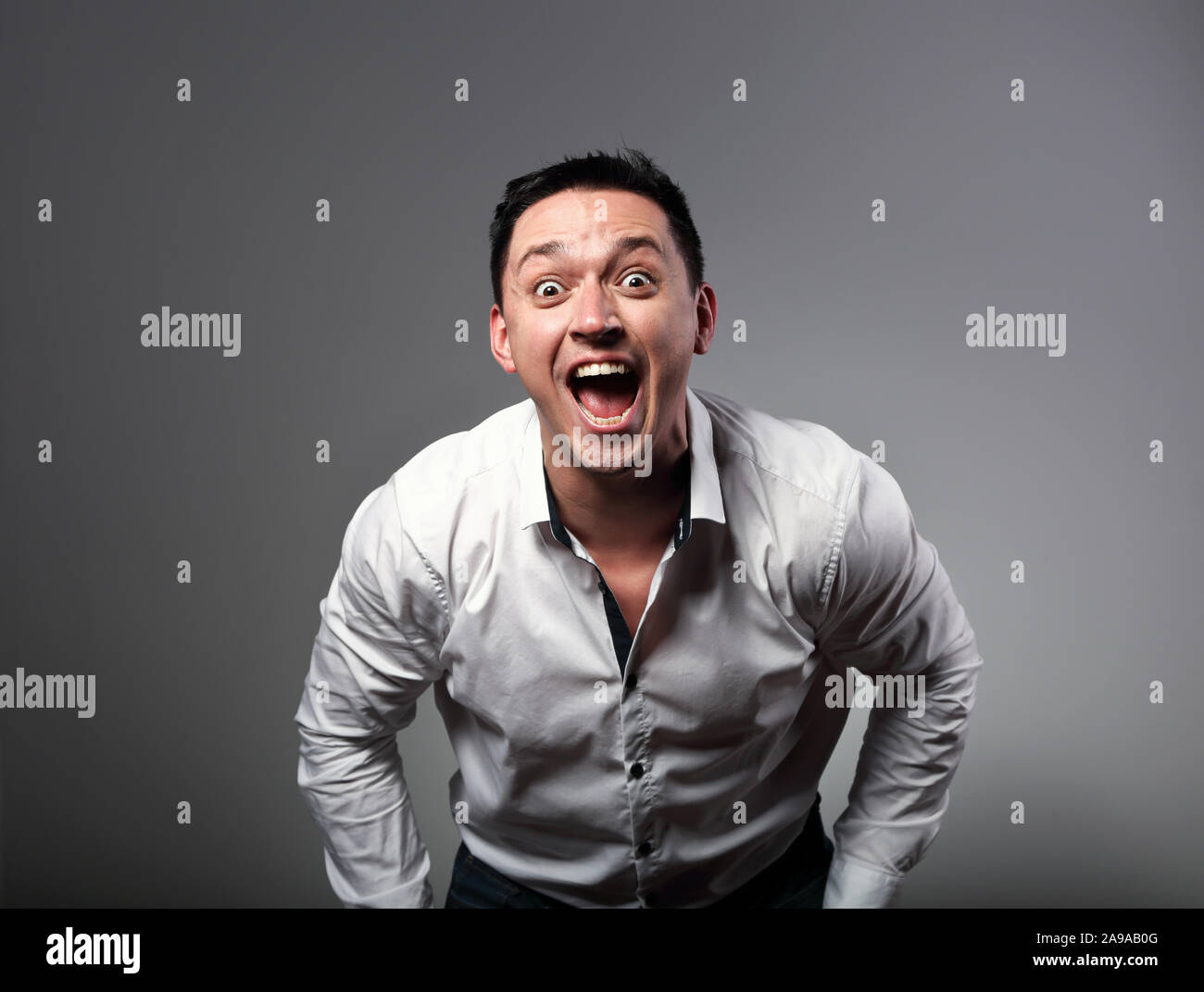 Excited crazy man shouting loud with wide opened mouth and mad eyes ...