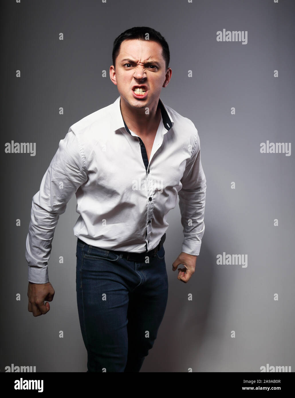 Angry young business man toothy grinning grimacing and aggressive eyes ...