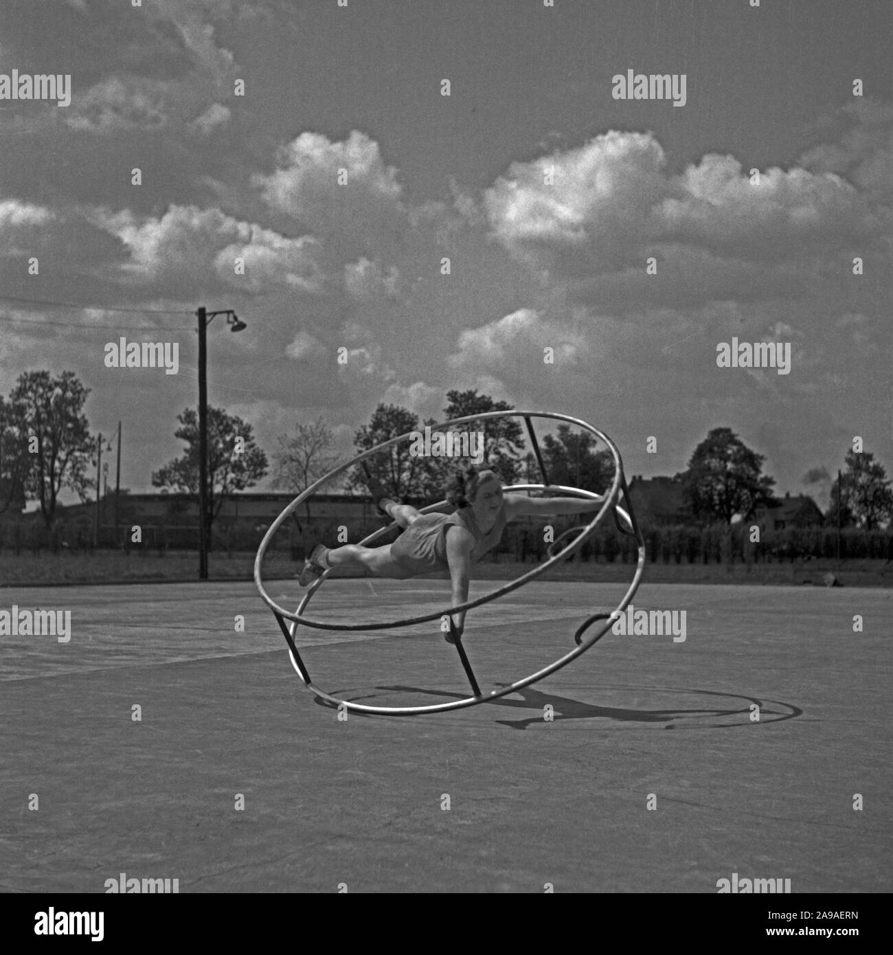 A young woman exercising with her gymwheel on a sporting ground ...