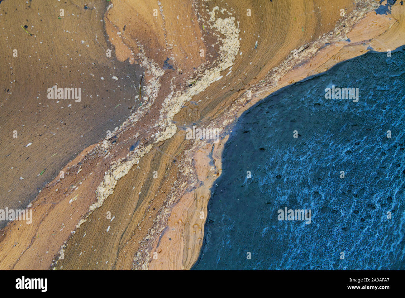 Abstract picture of a brown floating surface layer on blue water Stock ...