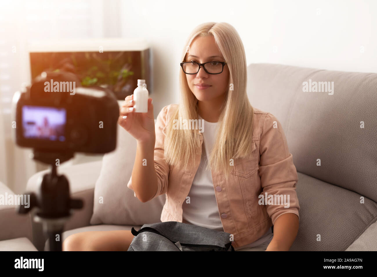 Famous blogger. Cheerful female vlogger is showing cosmetics products ...