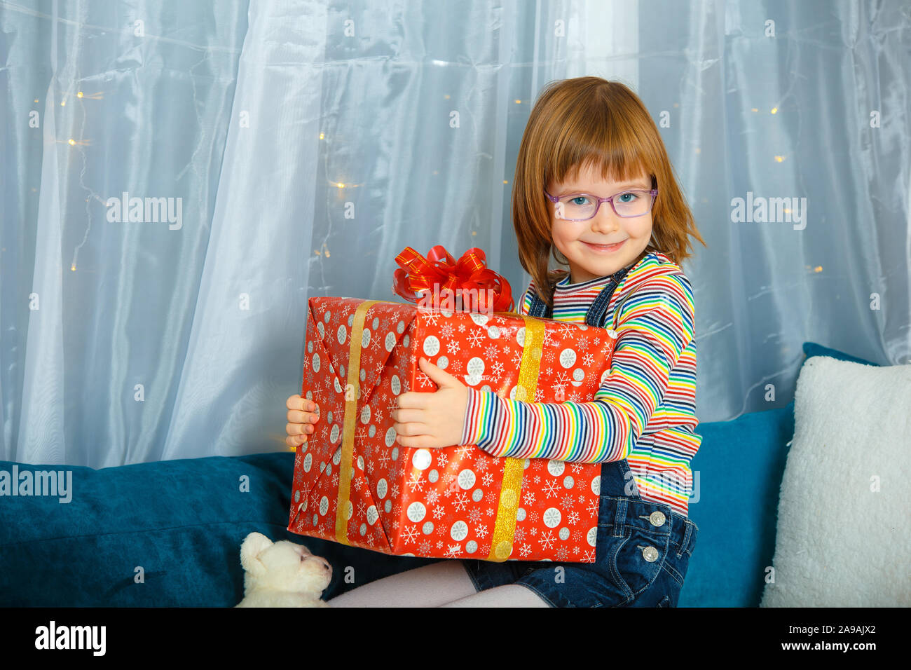 Girl Masha holding a box with a gift and smiling Stock Photo - Alamy