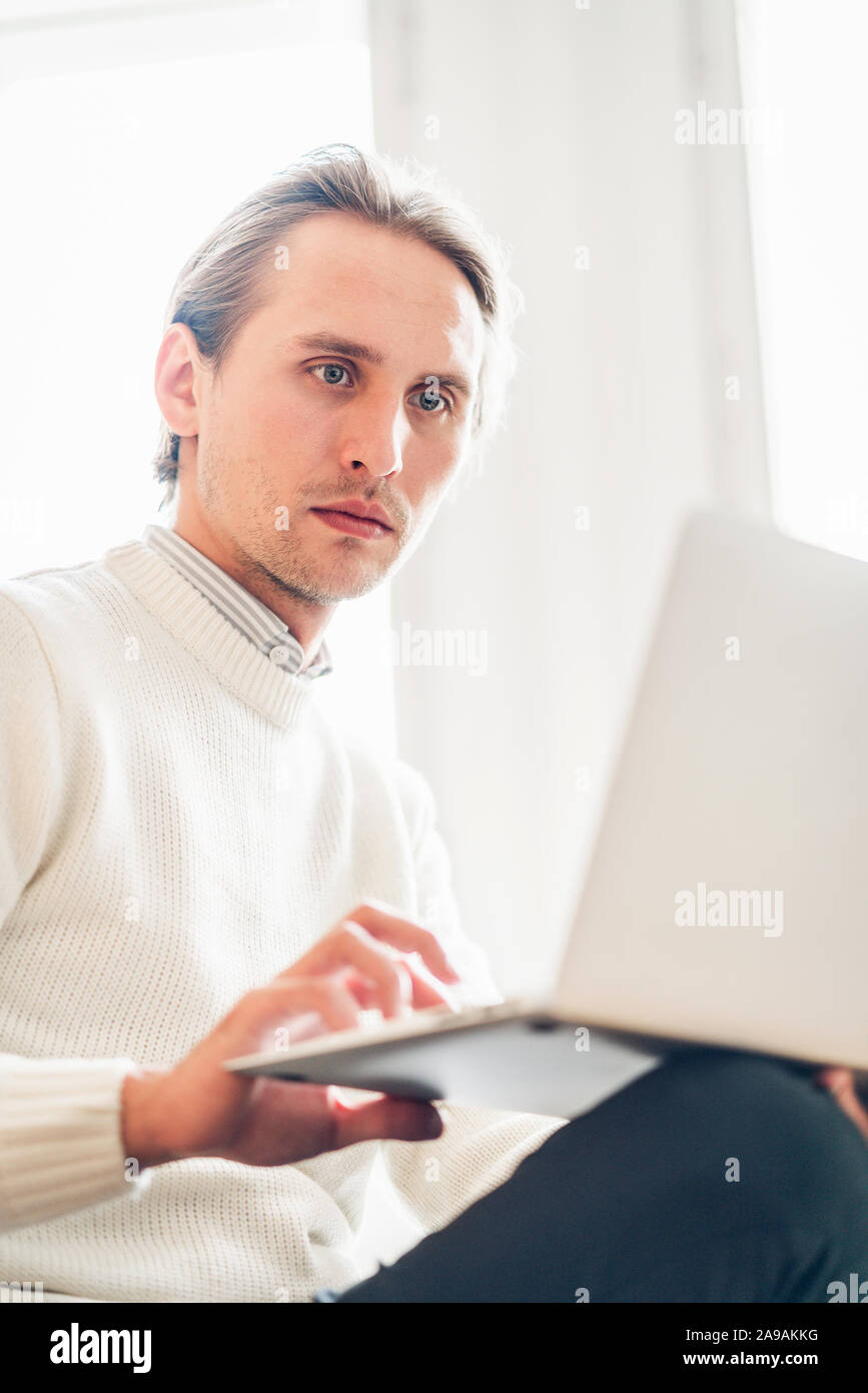 Young man looking at his portable computer. Bright light in the ...