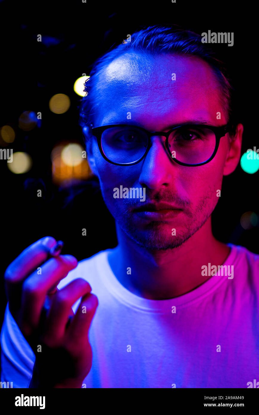 Vintage, red and blue portrait of a young man smoking a cigarette ...