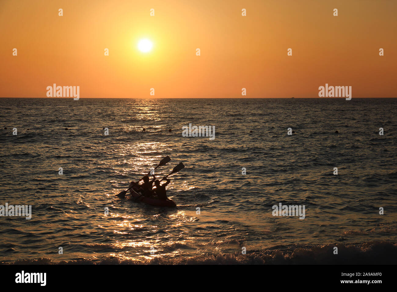 Two men rowing their boat in the Mediterranean sea during sunset Stock ...