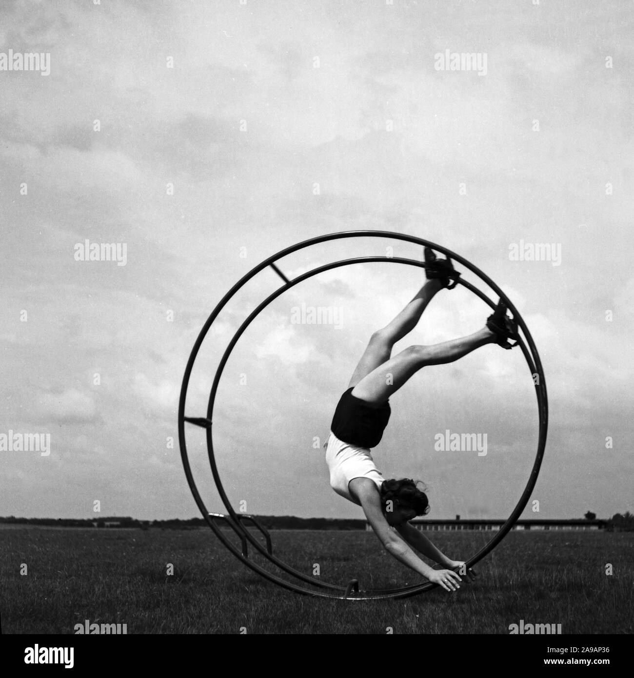 A woman doing gymnastics with the gymwheel, Germany 1930s Stock Photo ...