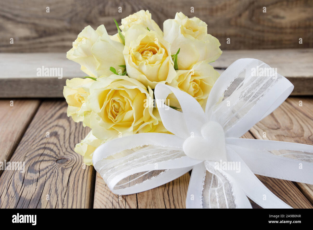 Roses and white ribbon with heart Stock Photo - Alamy