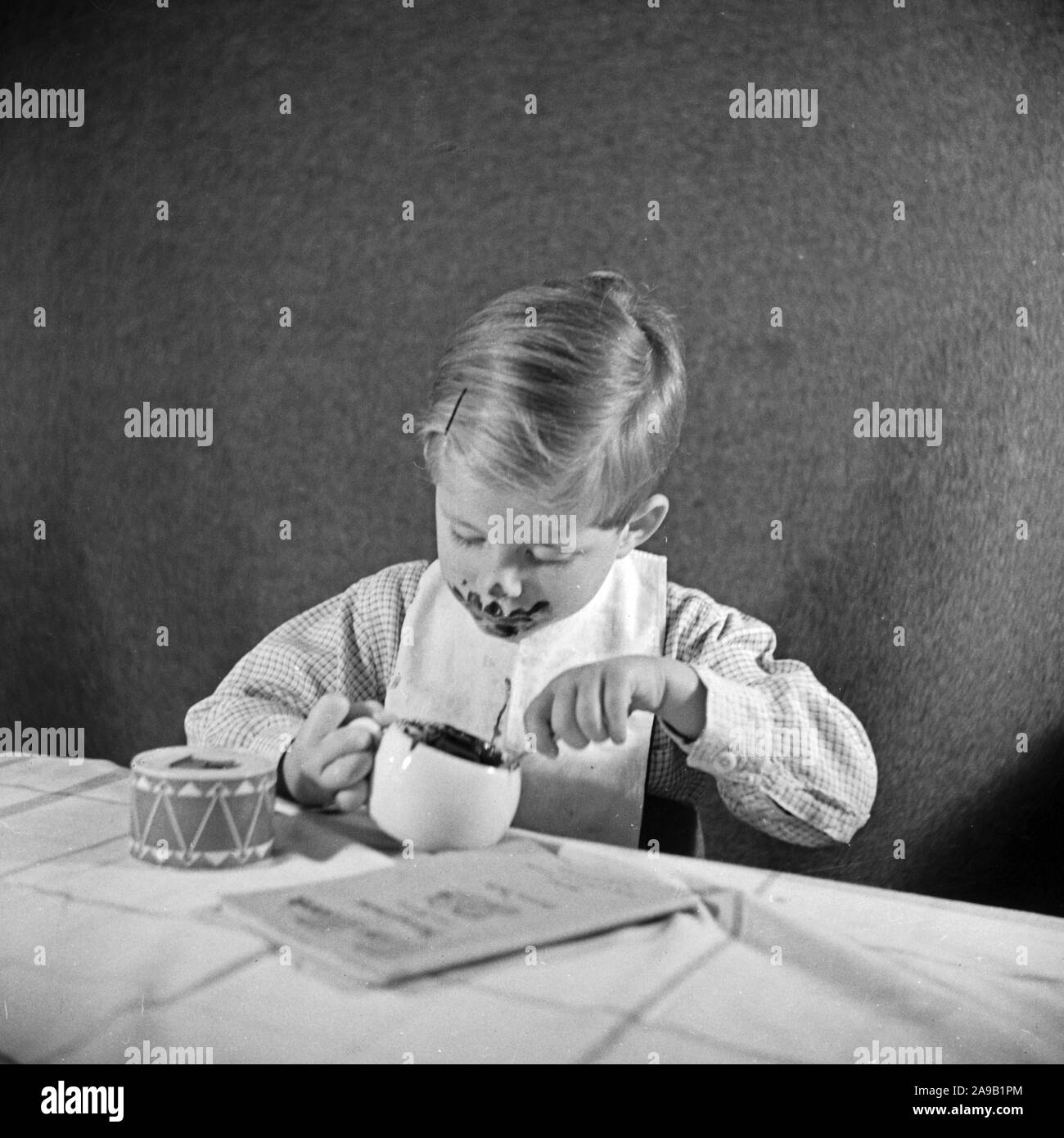 A little boy eating a chocolate pudding and is totally smeared, Germany ...
