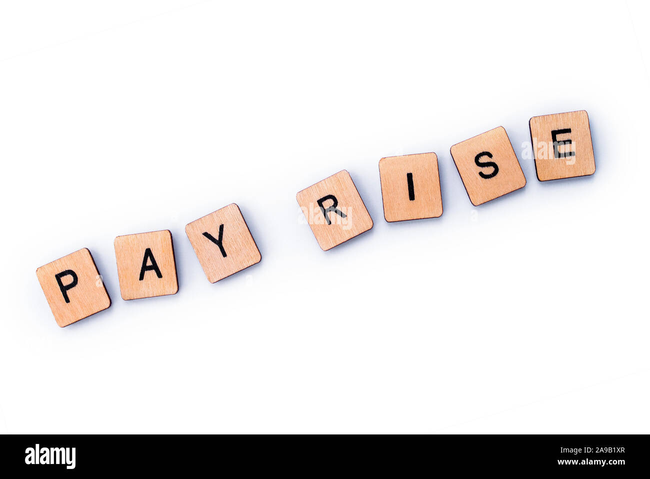 PAY RISE, spelt out with wooden letter tiles Stock Photo - Alamy