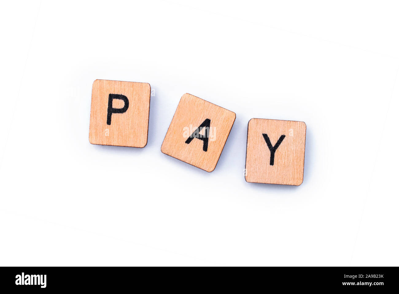 The word PAY, spelt out with wooden letter tiles Stock Photo - Alamy