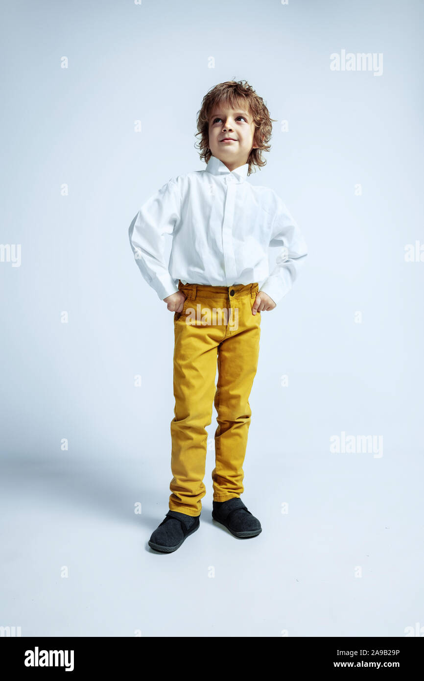 Pretty young boy in casual clothes on white studio background ...