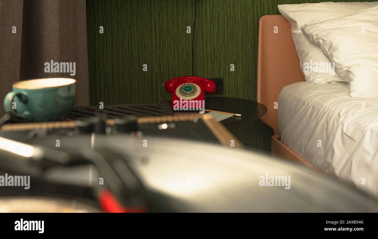 Vintage interior design in a hotel room, focus on the red telephone ...