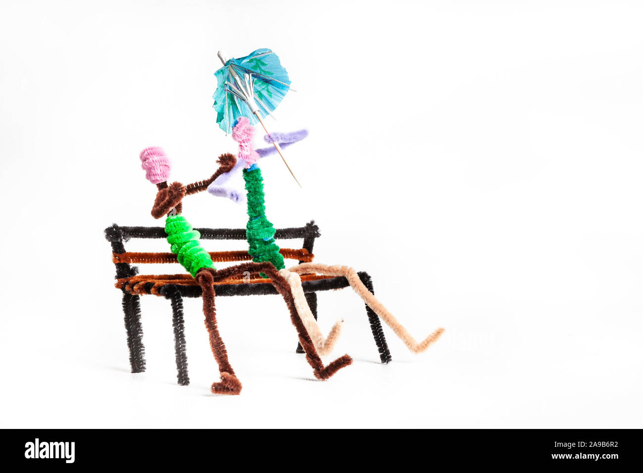 Pipe cleaner figures sitting on a pipe clearn bench Stock Photo - Alamy
