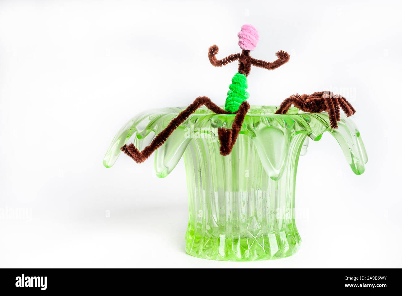 Pipe cleaner figures sitting on a green glass vase Stock Photo - Alamy