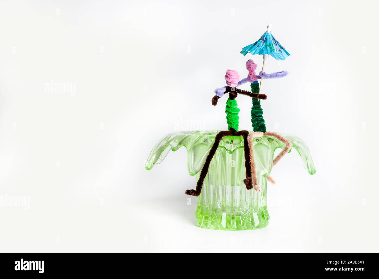 Pipe cleaner figures sitting on a green glass vase Stock Photo - Alamy