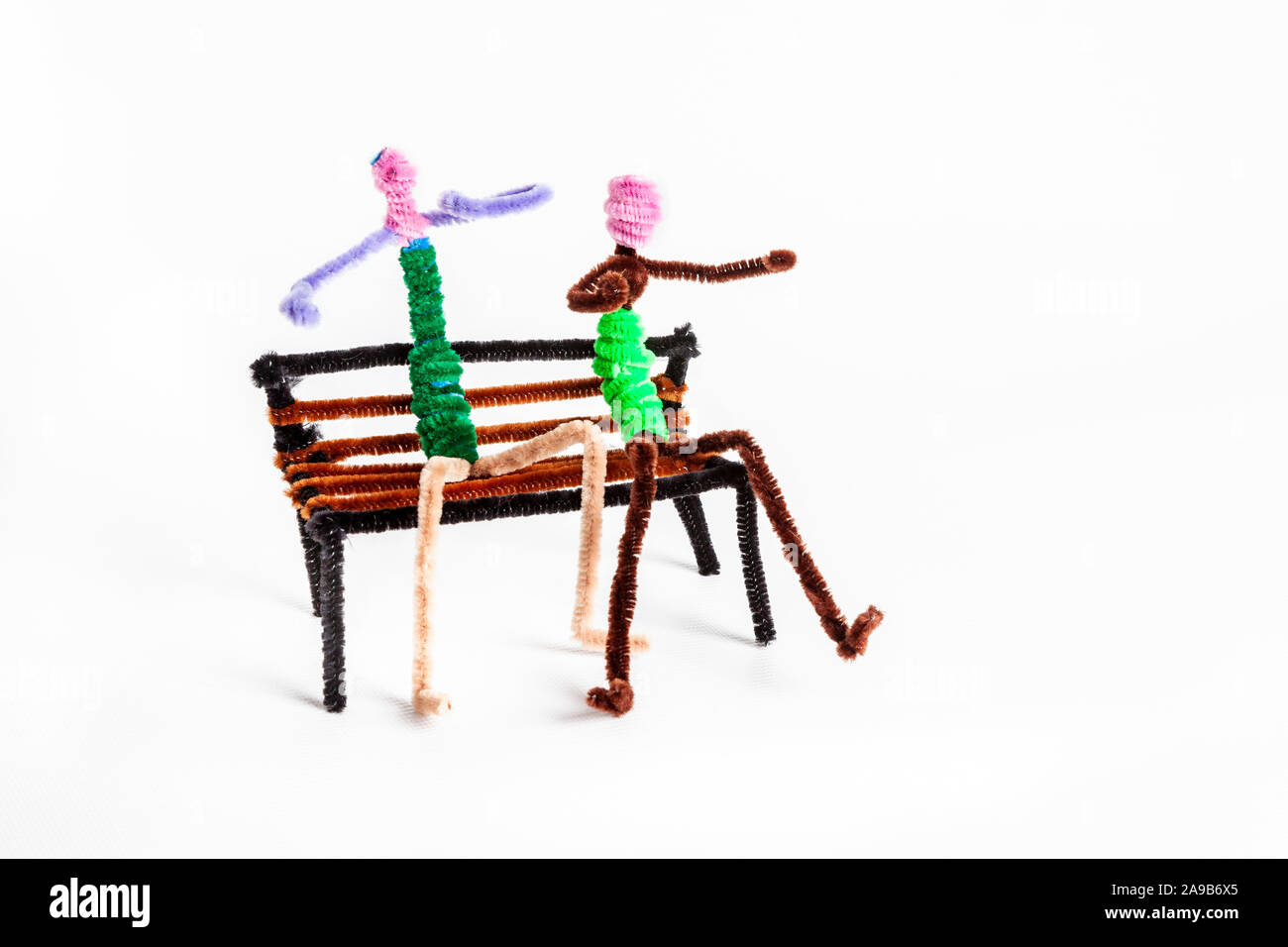 Pipe cleaner figures sitting on a pipe clearn bench Stock Photo - Alamy