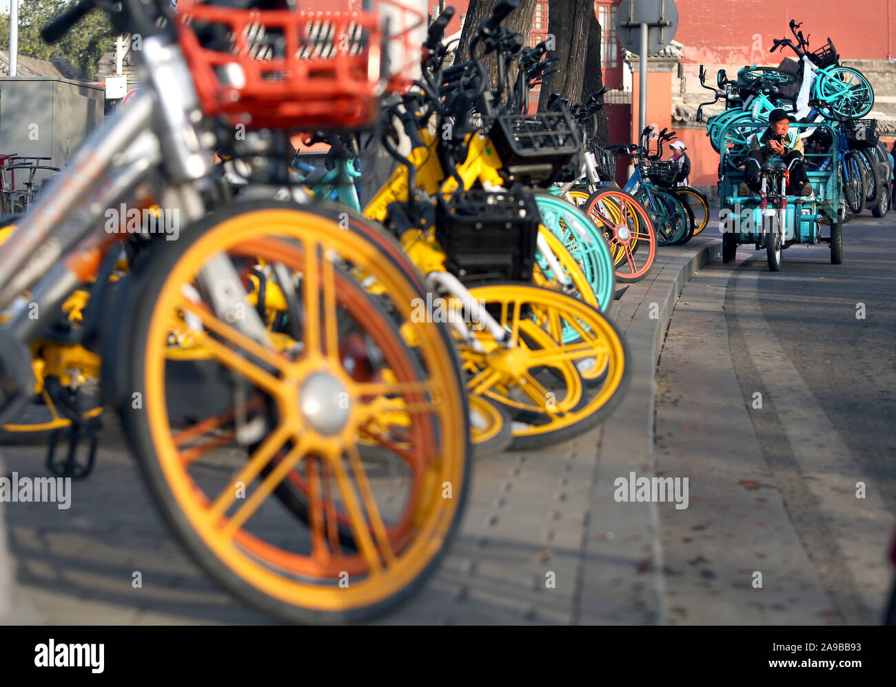 Beijing, China. 14th Nov, 2019. A Chinese man picks up rent-a-bikes on ...