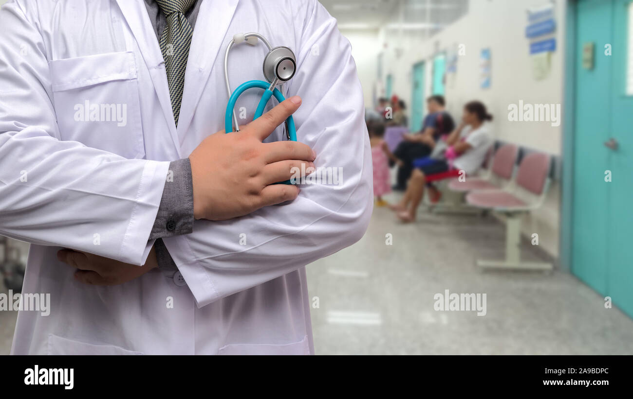Doctor in gown uniform with stethoscope standing and fold his arms over ...