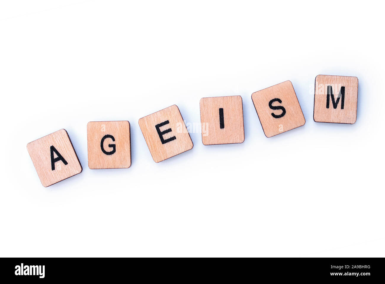 he word AGEISM, spelt with wooden letter tiles over a white background ...