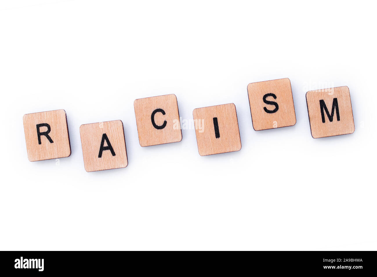 The word RACISM, spelt with wooden letter tiles over a white background ...