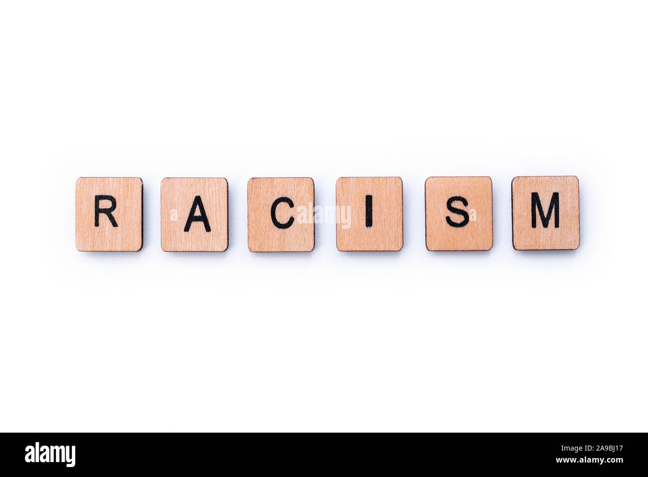 The word RACISM, spelt with wooden letter tiles over a white background ...
