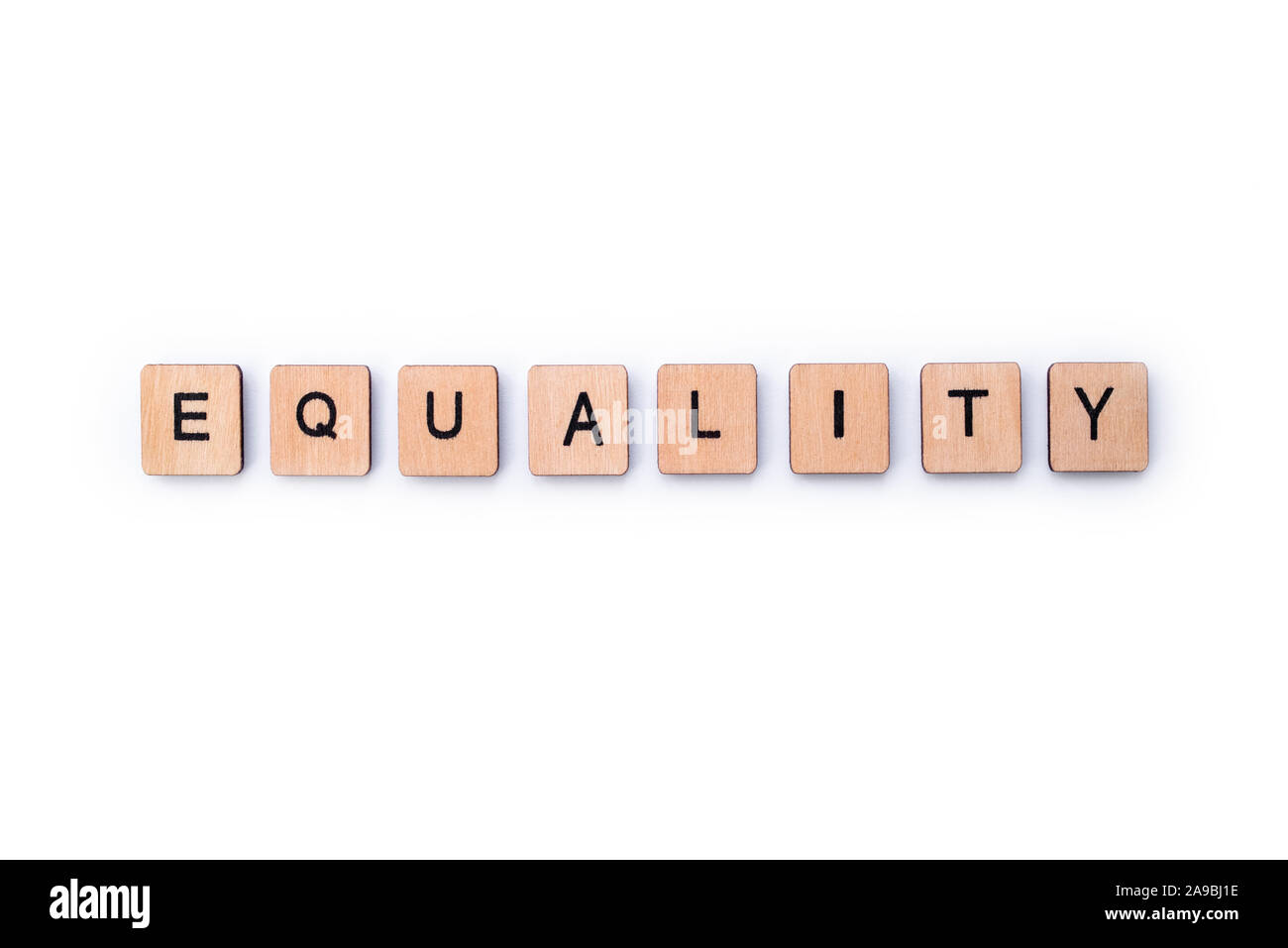 The word EQUALITY, spelt with wooden letter tiles over a white ...