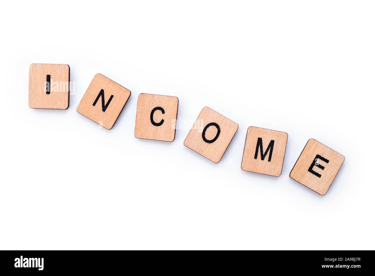 The word INCOME, spelt with wooden letter tiles over a white background ...
