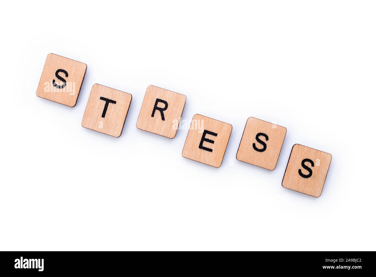 The word STRESS, spelt with wooden letter tiles over a white background ...