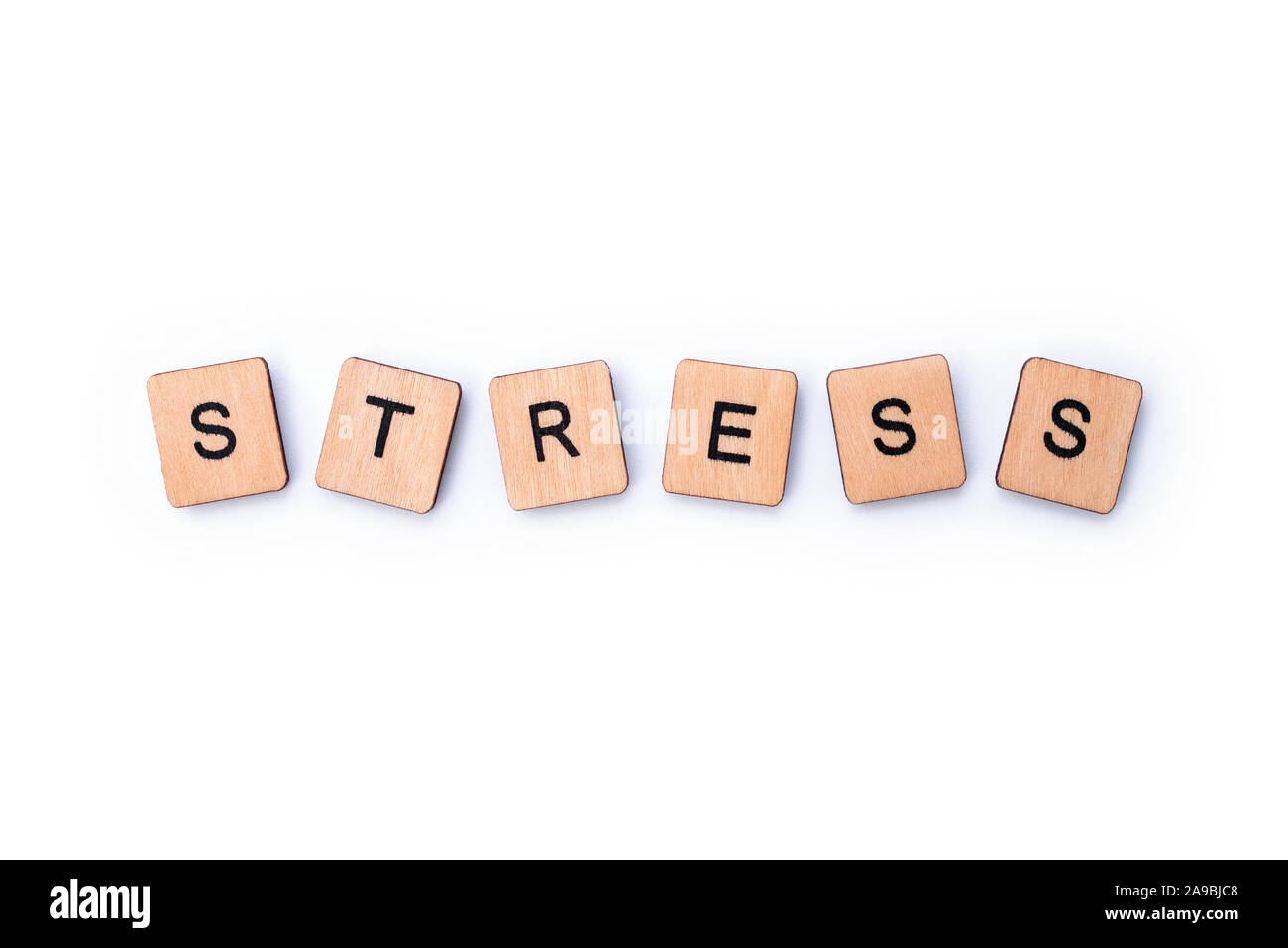 The word STRESS, spelt with wooden letter tiles over a white background ...