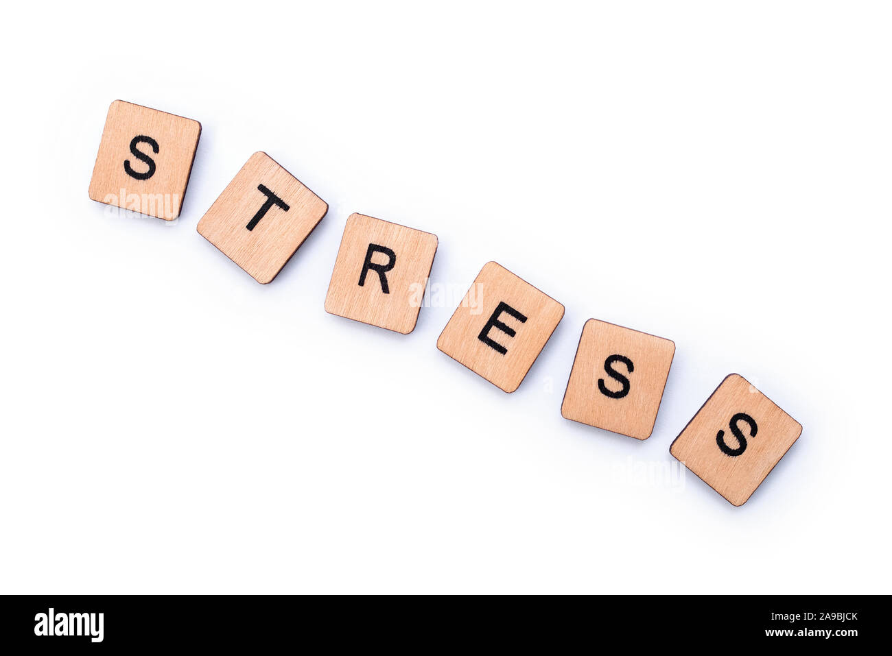 The word STRESS, spelt with wooden letter tiles over a white background ...