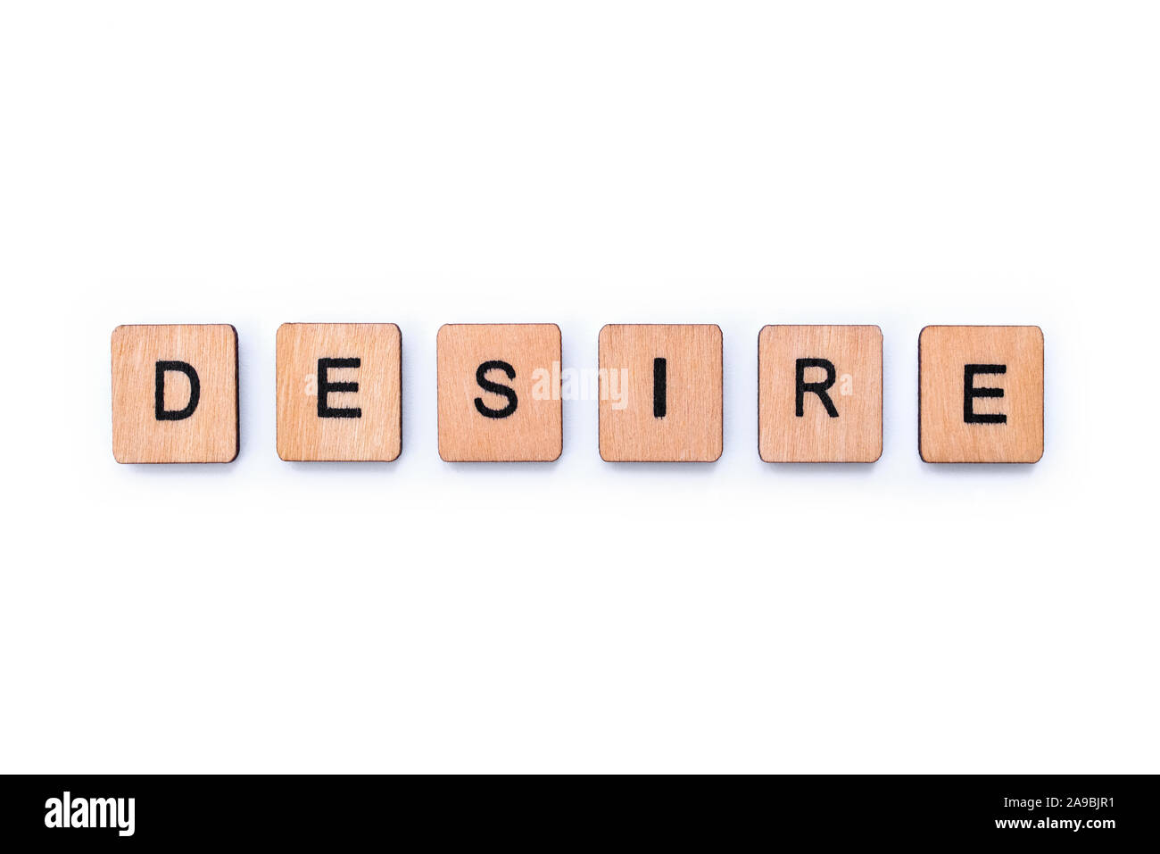 The word DESIRE, spelt with wooden letter tiles over a white background ...