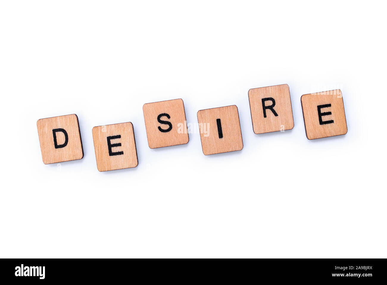 The word DESIRE, spelt with wooden letter tiles over a white background ...