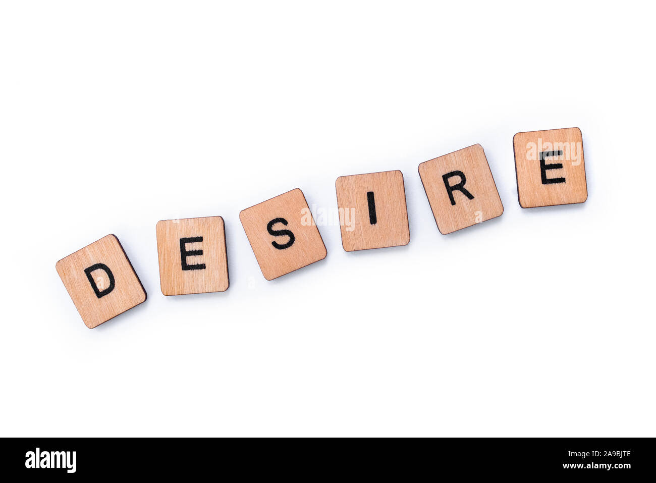 The word DESIRE, spelt with wooden letter tiles over a white background ...