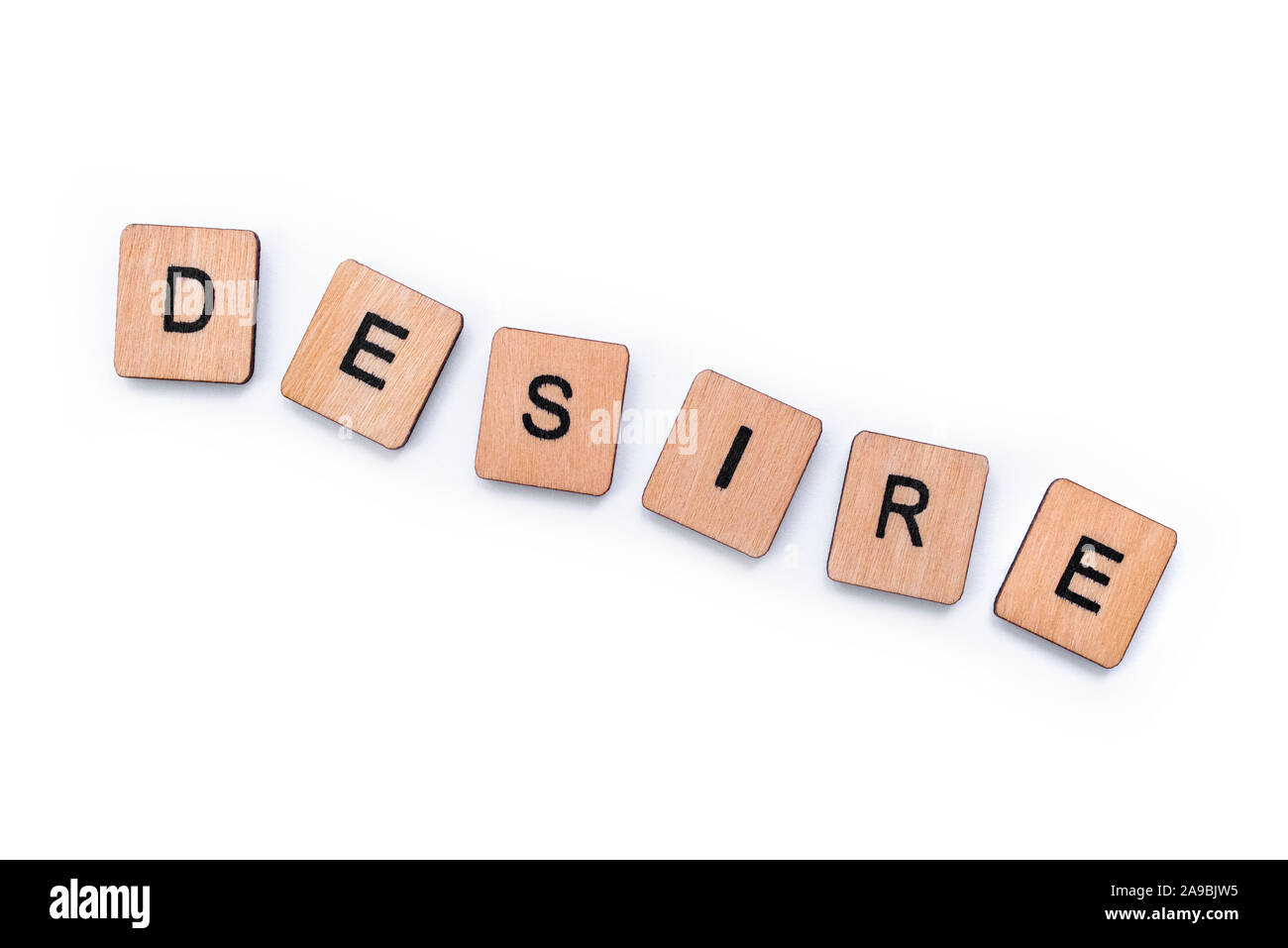 The word DESIRE, spelt with wooden letter tiles over a white background ...